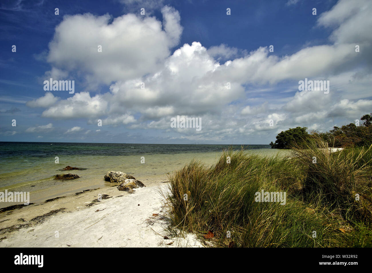 tropical beach shoreline with rocks and dramatic clouds Stock Photo - Alamy
