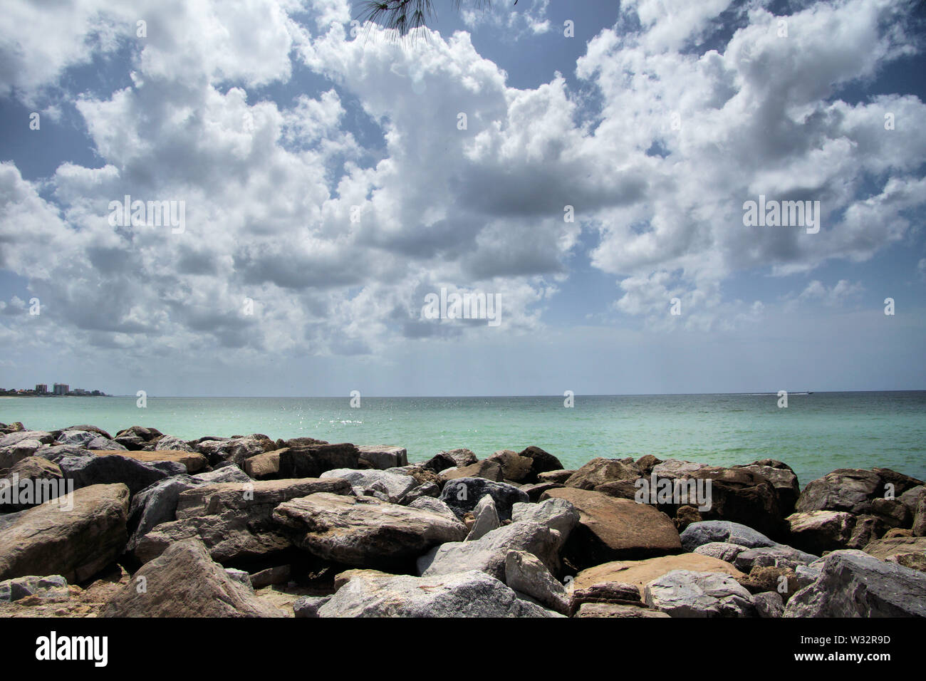 tropical beach shoreline with rocks and dramatic clouds Stock Photo - Alamy