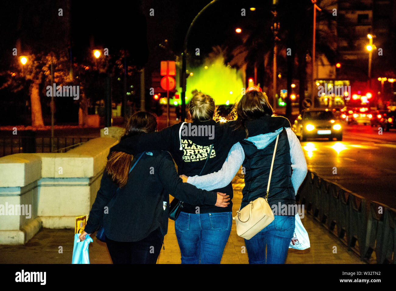 Three friends walking at night in Spain Stock Photo - Alamy
