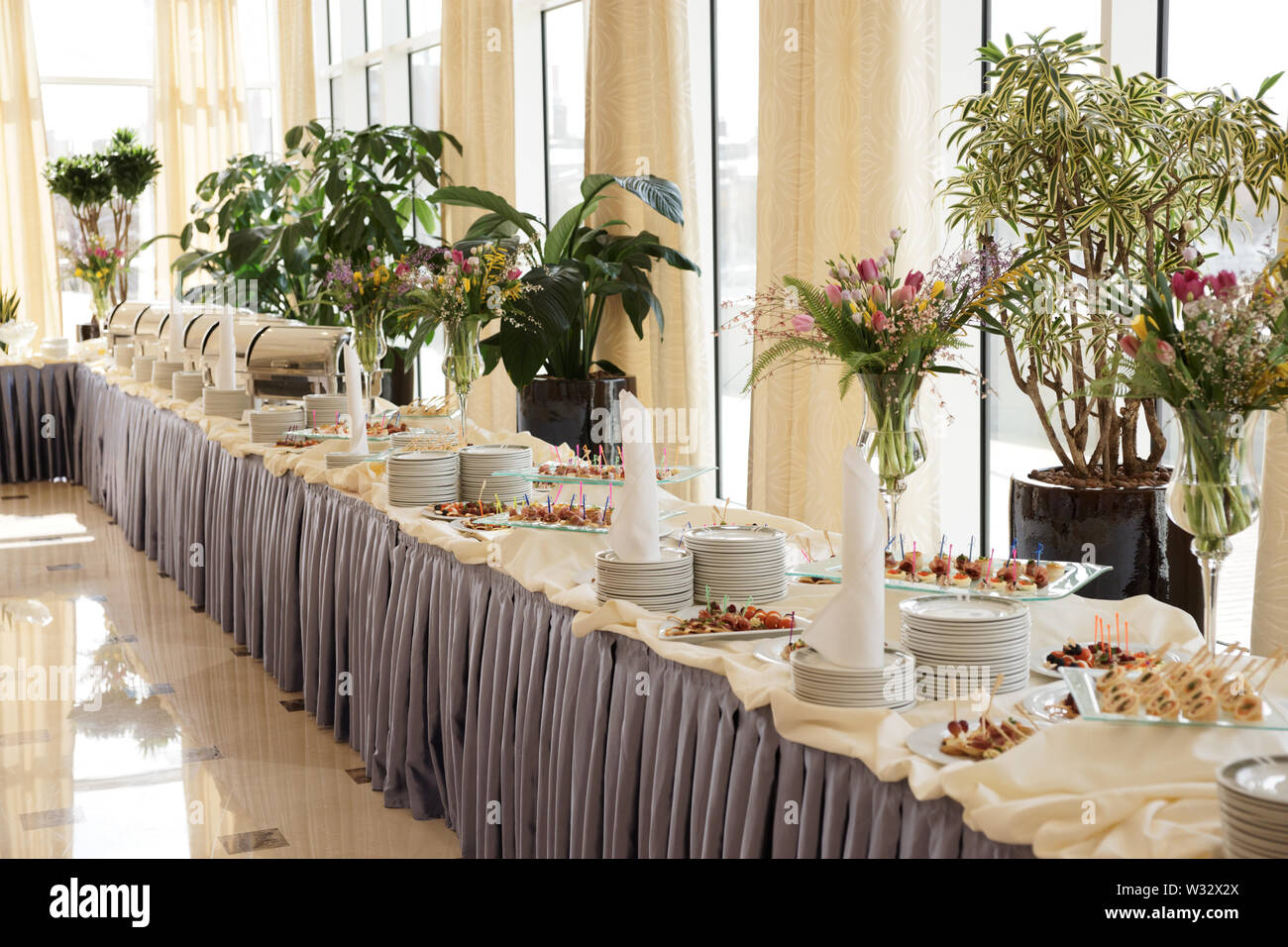 Table with dishware and tasty food waiting for guests Stock Photo - Alamy