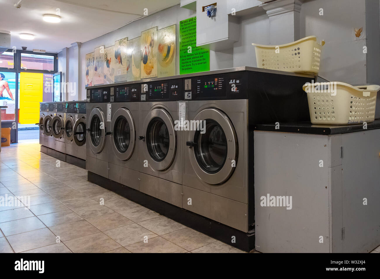 London, UK - May 19 2018: Row of coin laundries and cloth dryers in a ...