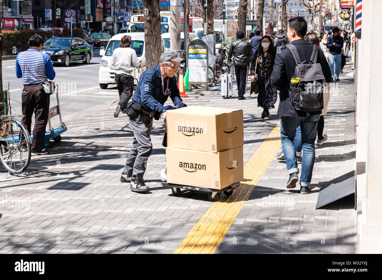 Tokyo, Japan - April 4, 2019: Senior old delivery man pushing dolly ...