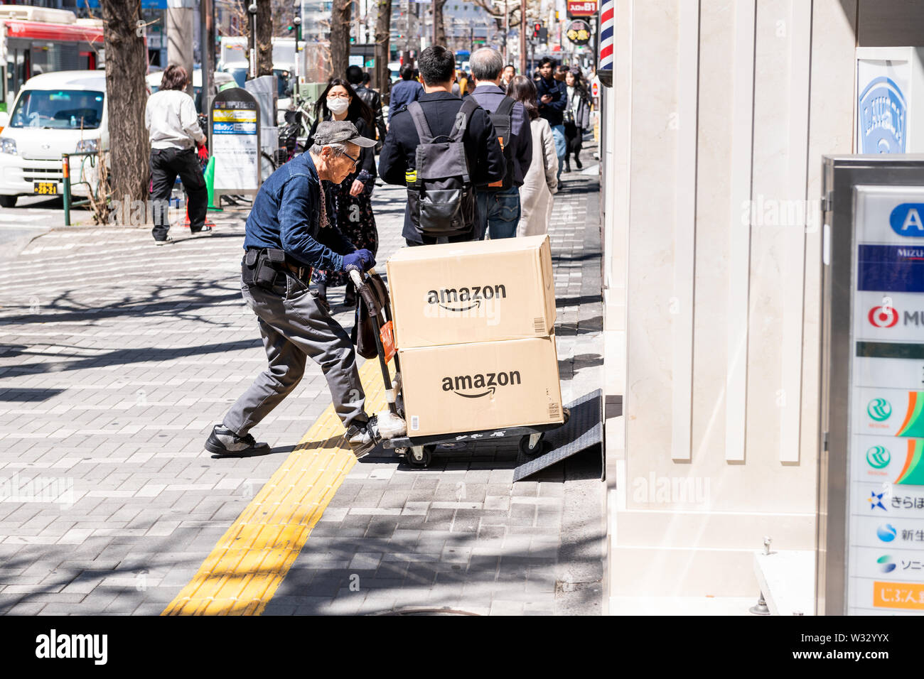 Tokyo, Japan - April 4, 2019: Senior old delivery man worker pushing ...