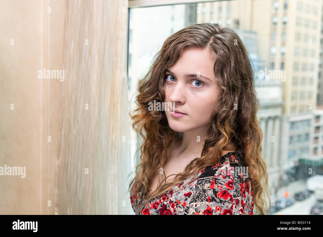Modern buildings window and closeup portrait of young woman girl face ...