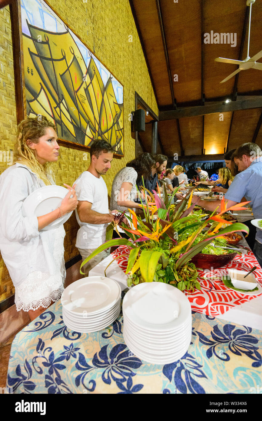 Tourists helping themselves to dinner at a buffet, Aitutaki, Cook ...