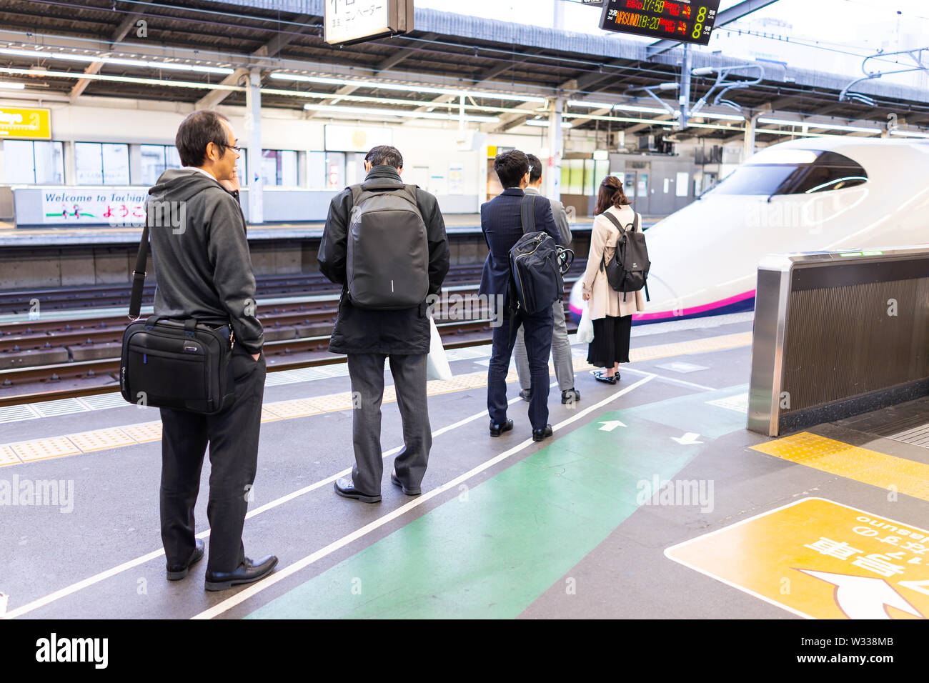 Utsunomiya, Japan - April 4, 2019: Business people, businessman in suit with backpack waiting in ...