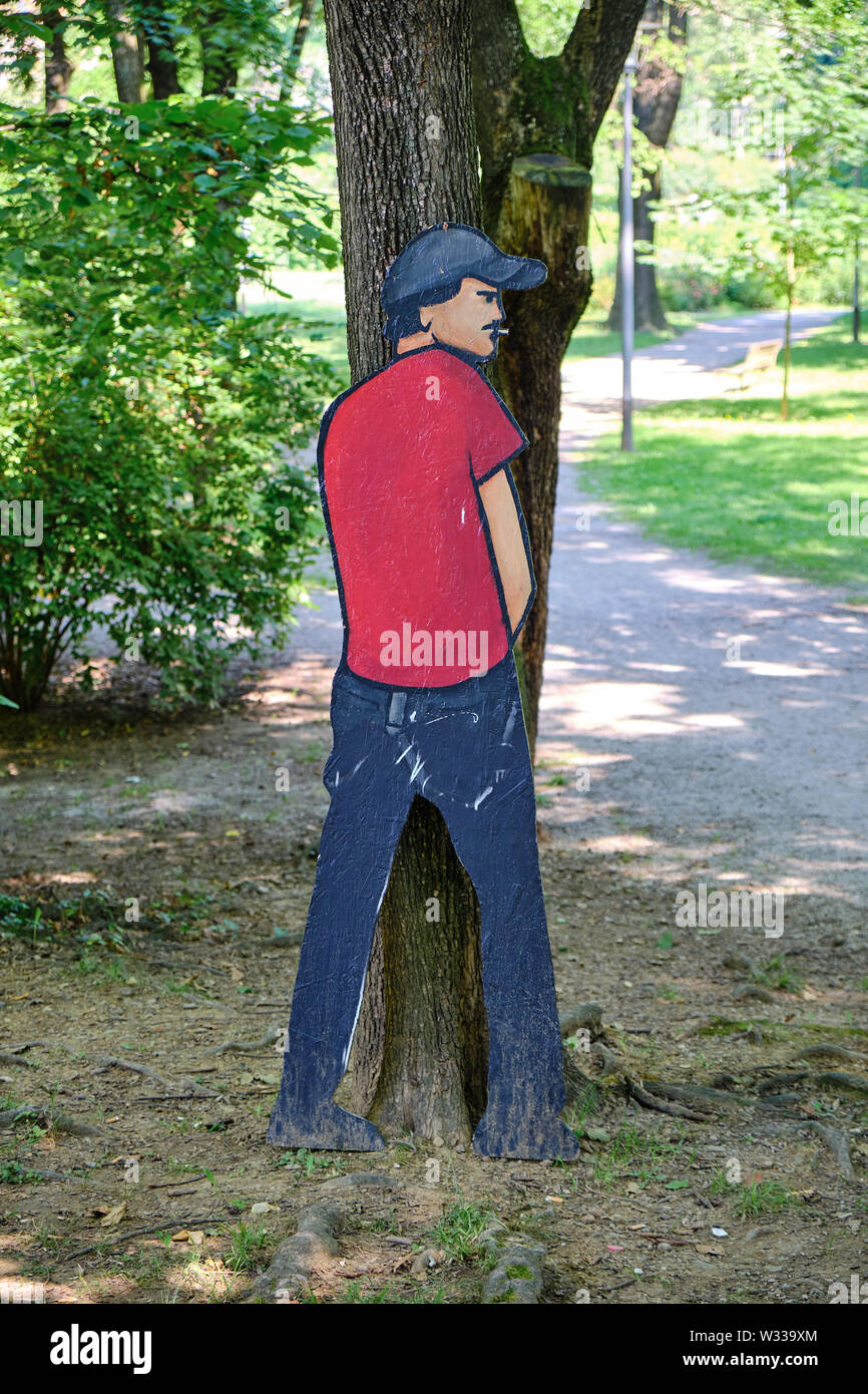 Trompe l'oeil cut out of a man figure in a park looking like he is ...
