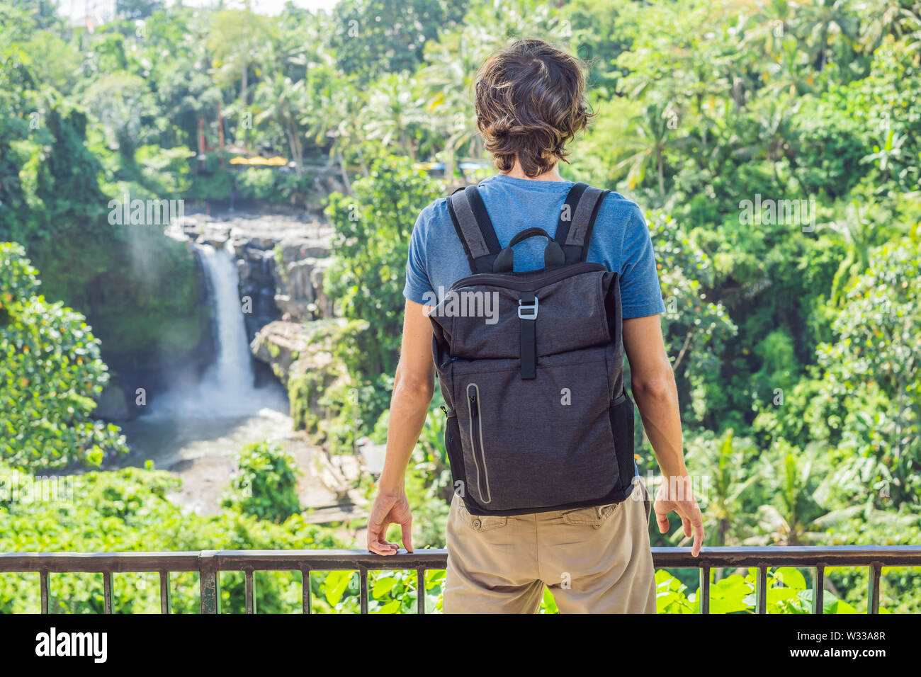 Man traveler on a waterfall background. Ecotourism concept Stock Photo ...