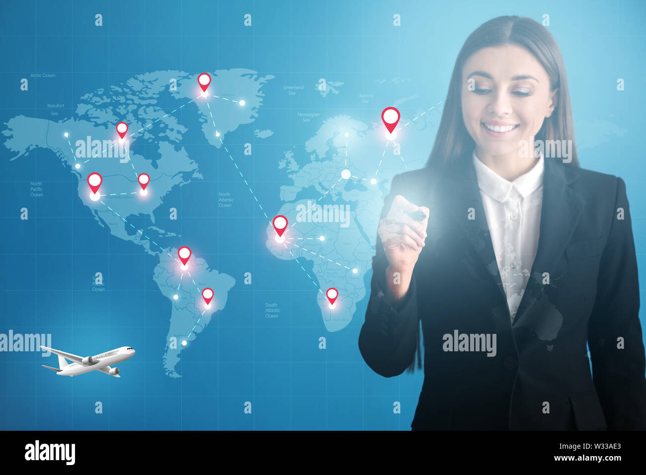 Female travel agent marking route on virtual world map Stock Photo - Alamy