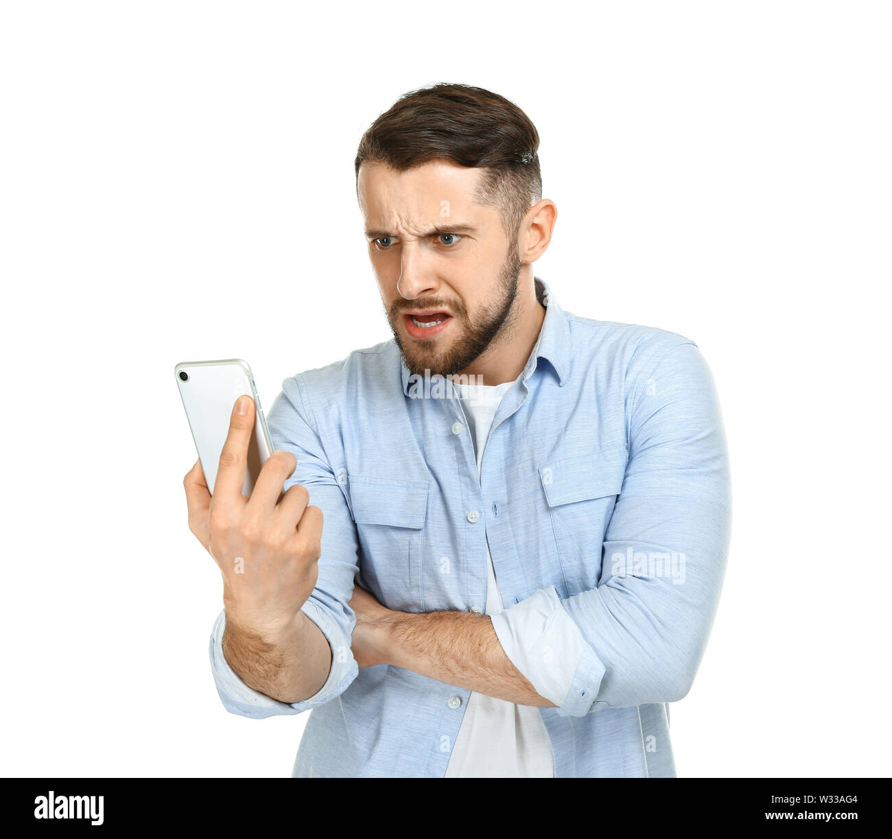 Angry man with mobile phone on white background Stock Photo - Alamy
