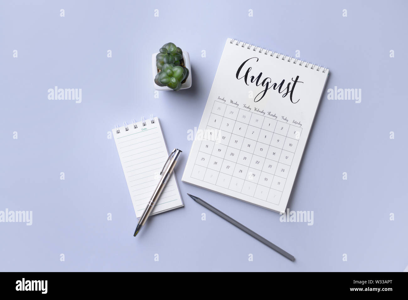 Flip paper calendar and notebook on light background Stock Photo - Alamy