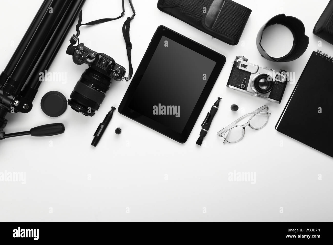 Tablet computer and set of photographer's equipment on white background ...