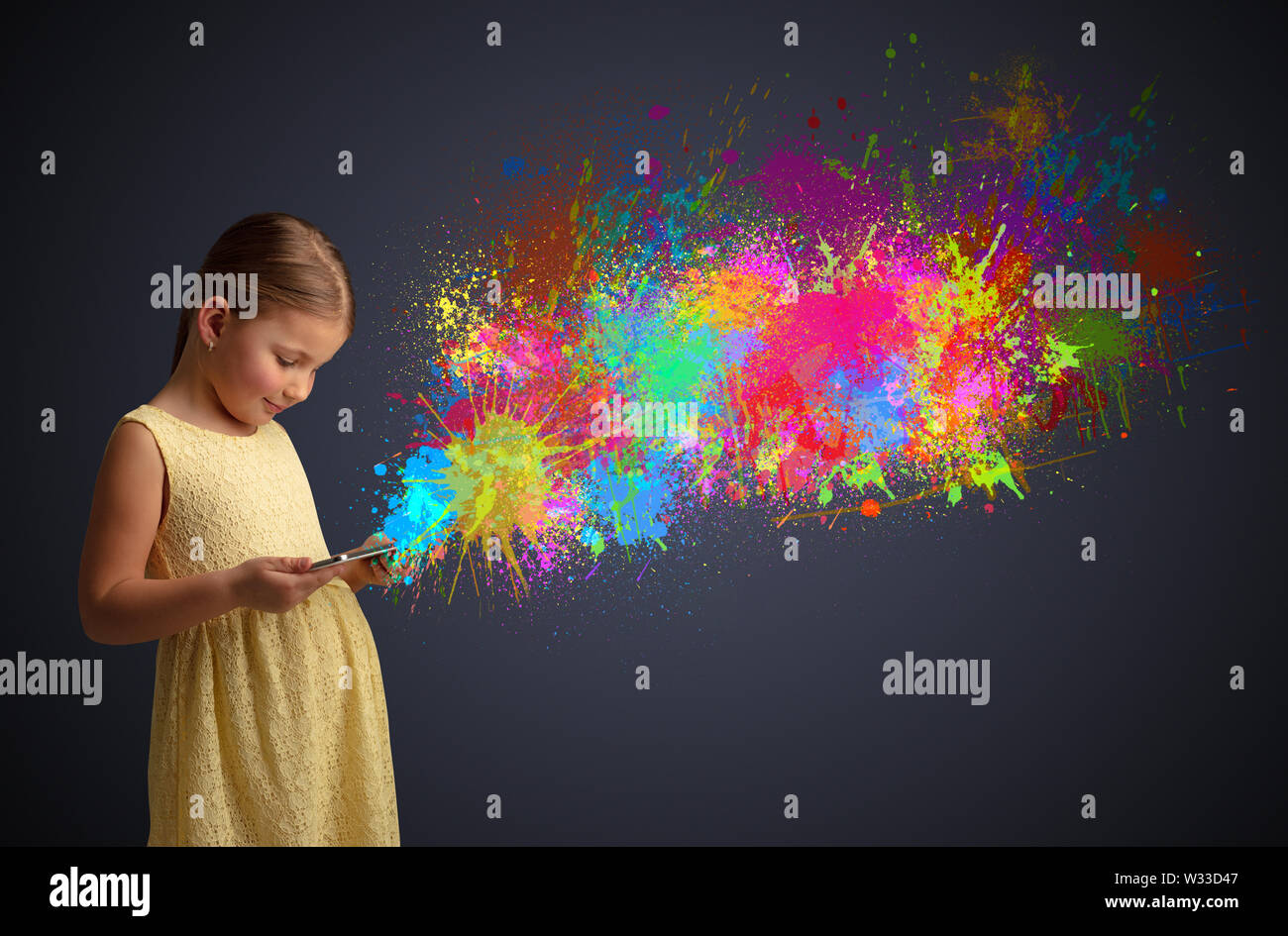 Cute little girl using tablet with colourful splash concept Stock Photo ...