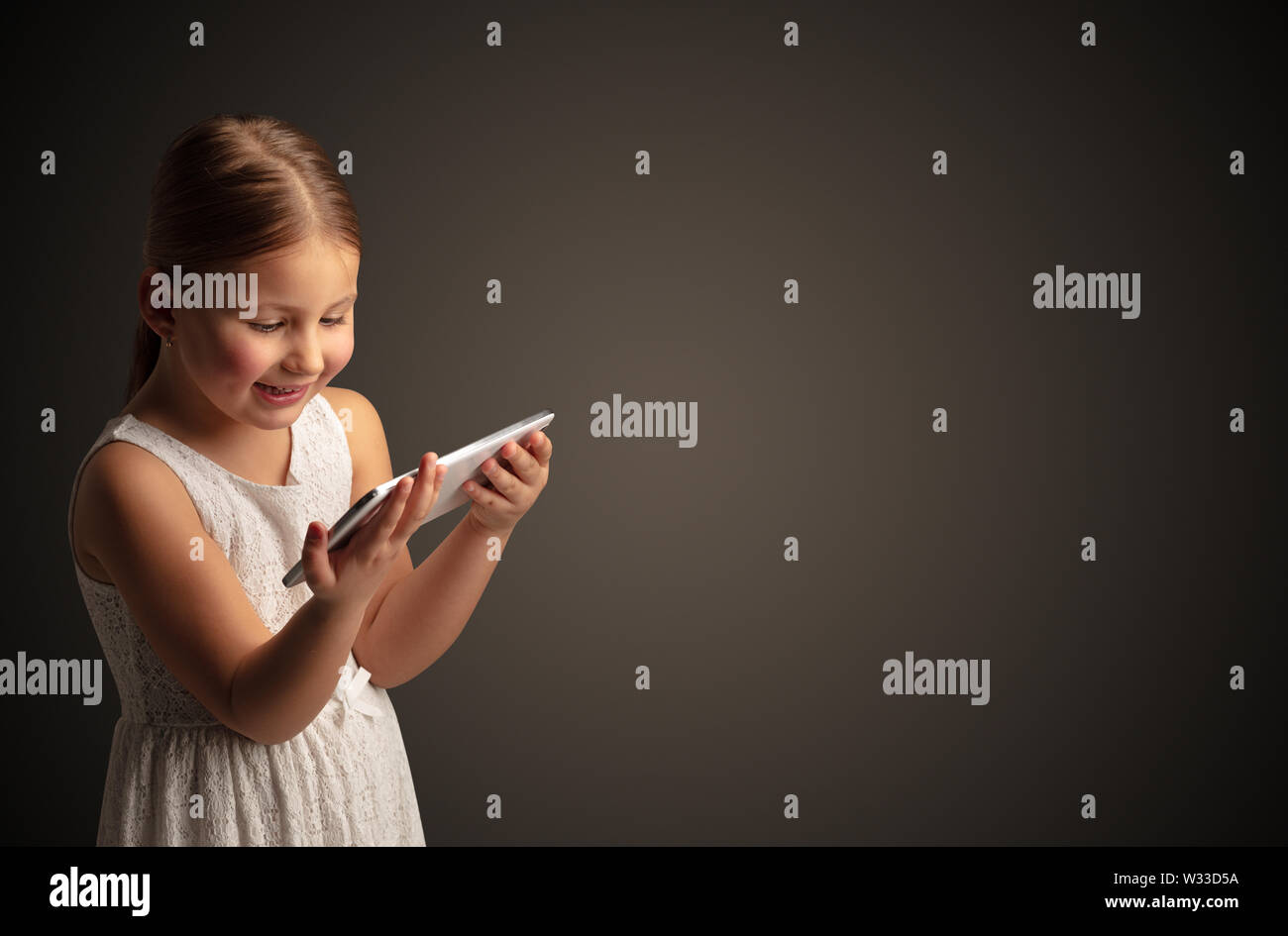 Adorable little girl using tablet with dark empty space Stock Photo - Alamy