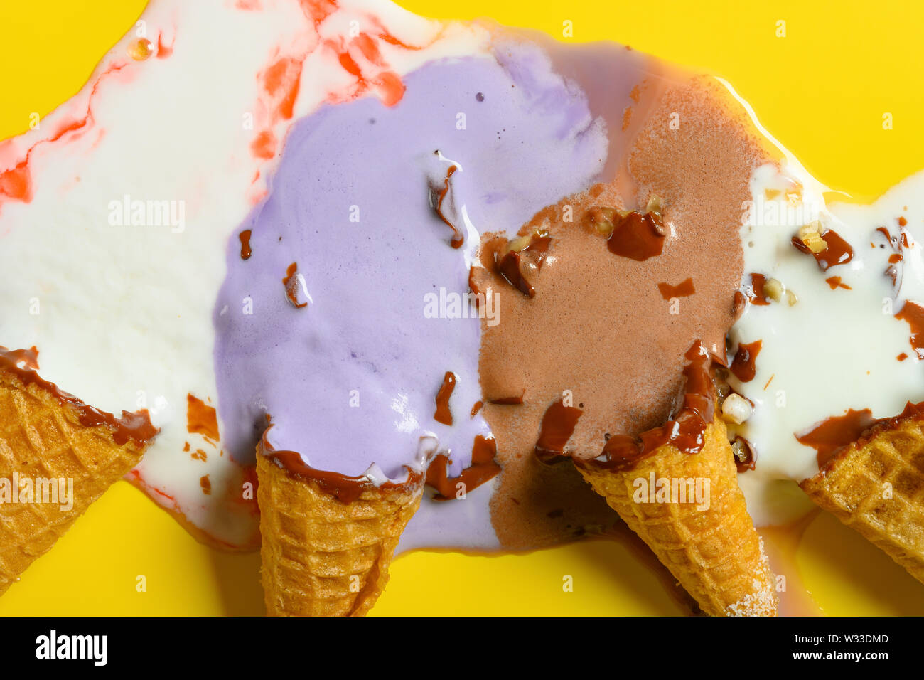 top view multiple flavor ice cream cones melted close up on yellow ...