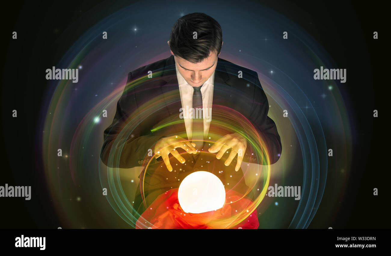 Young handsome man looking to the future of the universe in a crystal ...