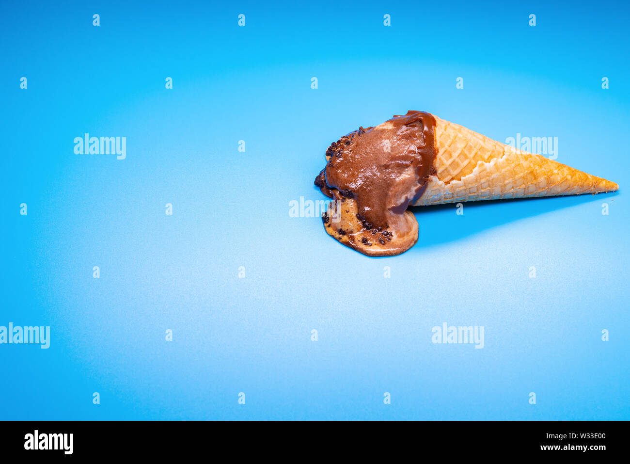 coffee flavor ice cream cone in a melting process on a blue background ...