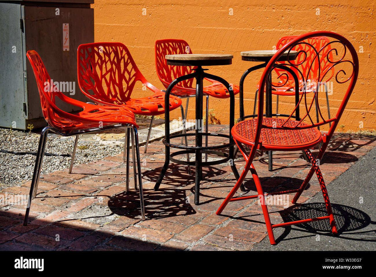 Bright red chairs, stackable and collapsible, and wooden tables in a ...