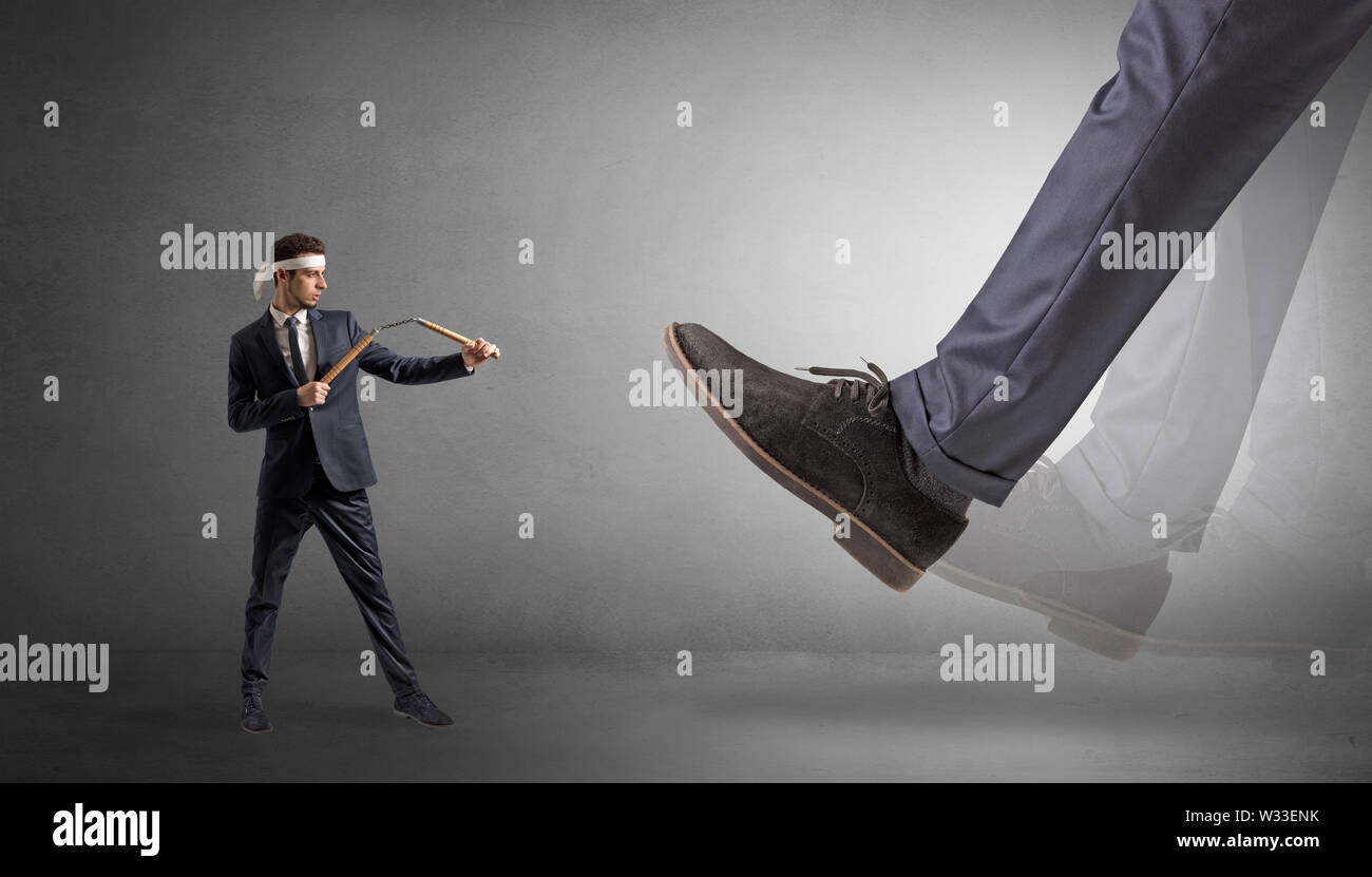 Big foot treading small young karate man Stock Photo - Alamy