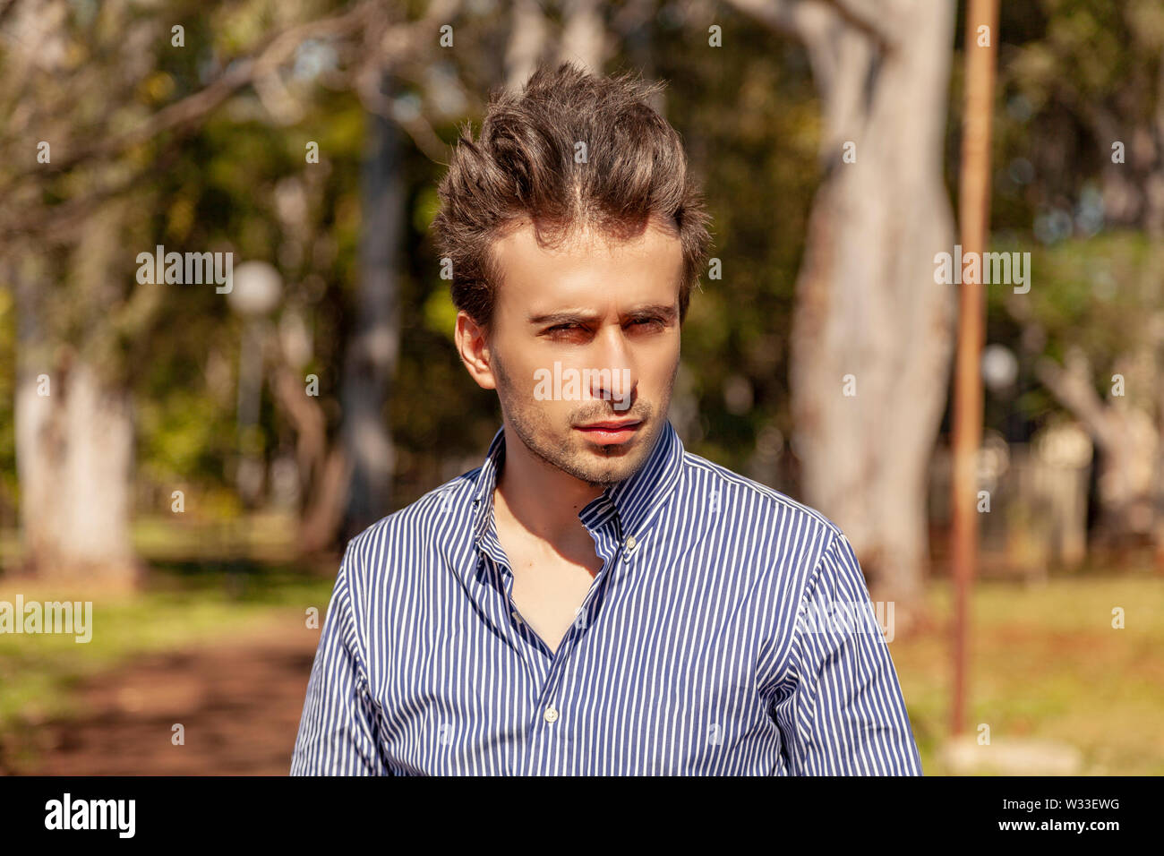 Pretty young man with tufted hair. Sensual man with hair style. Outside ...
