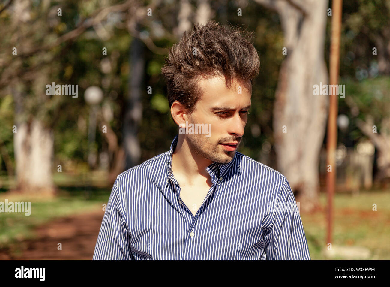 Pretty young man with tufted hair. Sensual man with hair style. Outside ...