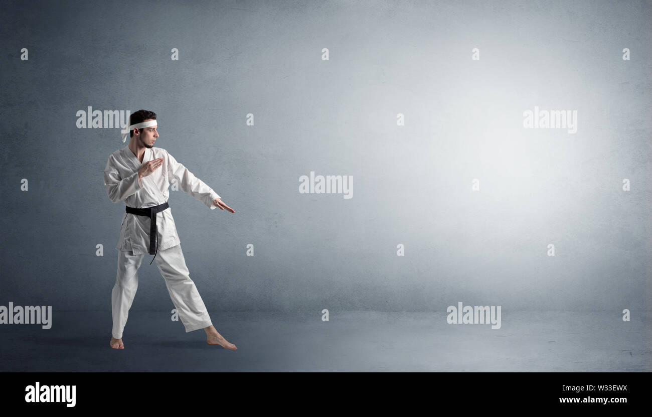 Small karate man fighting in an empty grey copy space Stock Photo - Alamy