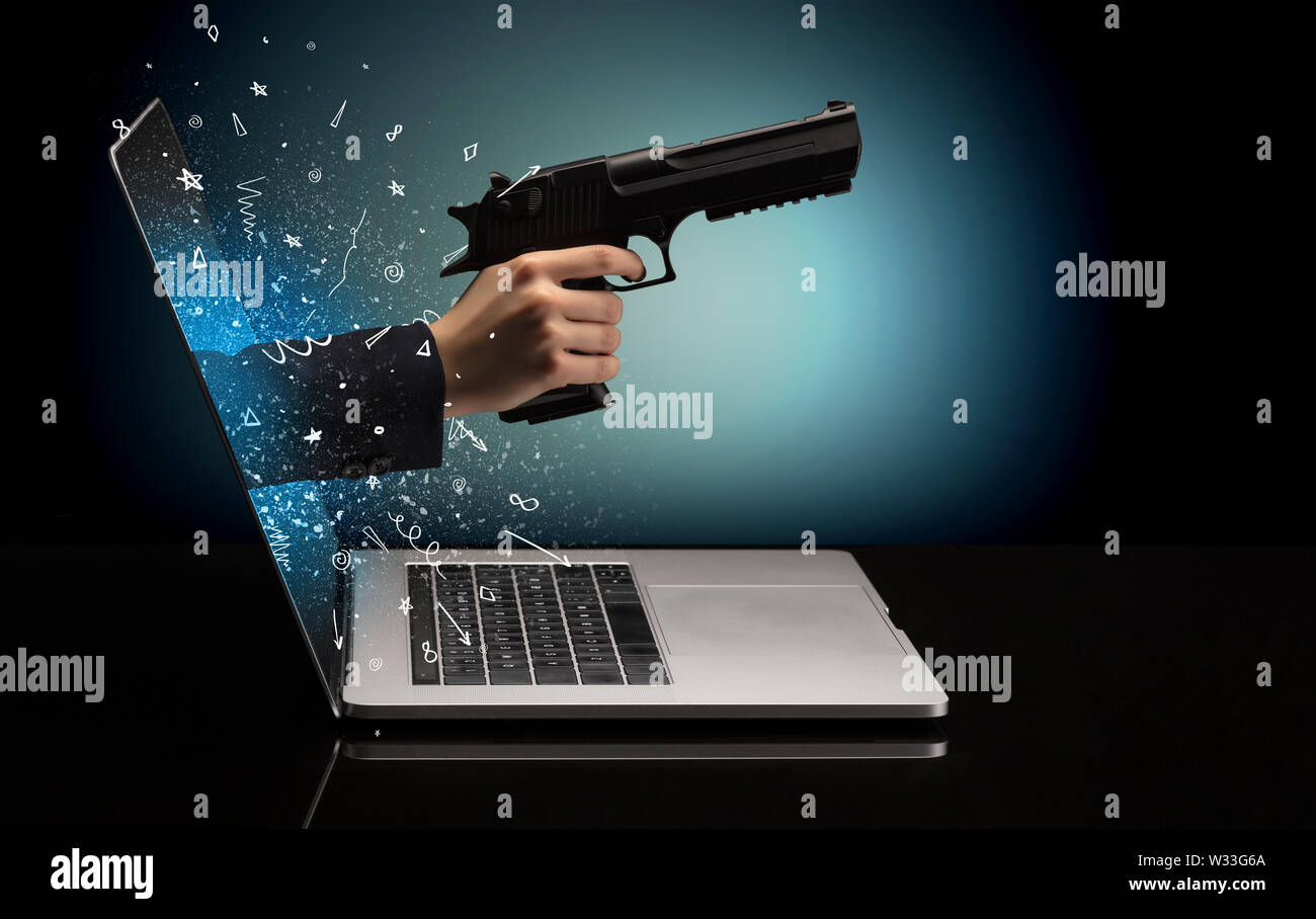 Hand with gun coming out of a laptop with sparkling effects Stock Photo ...