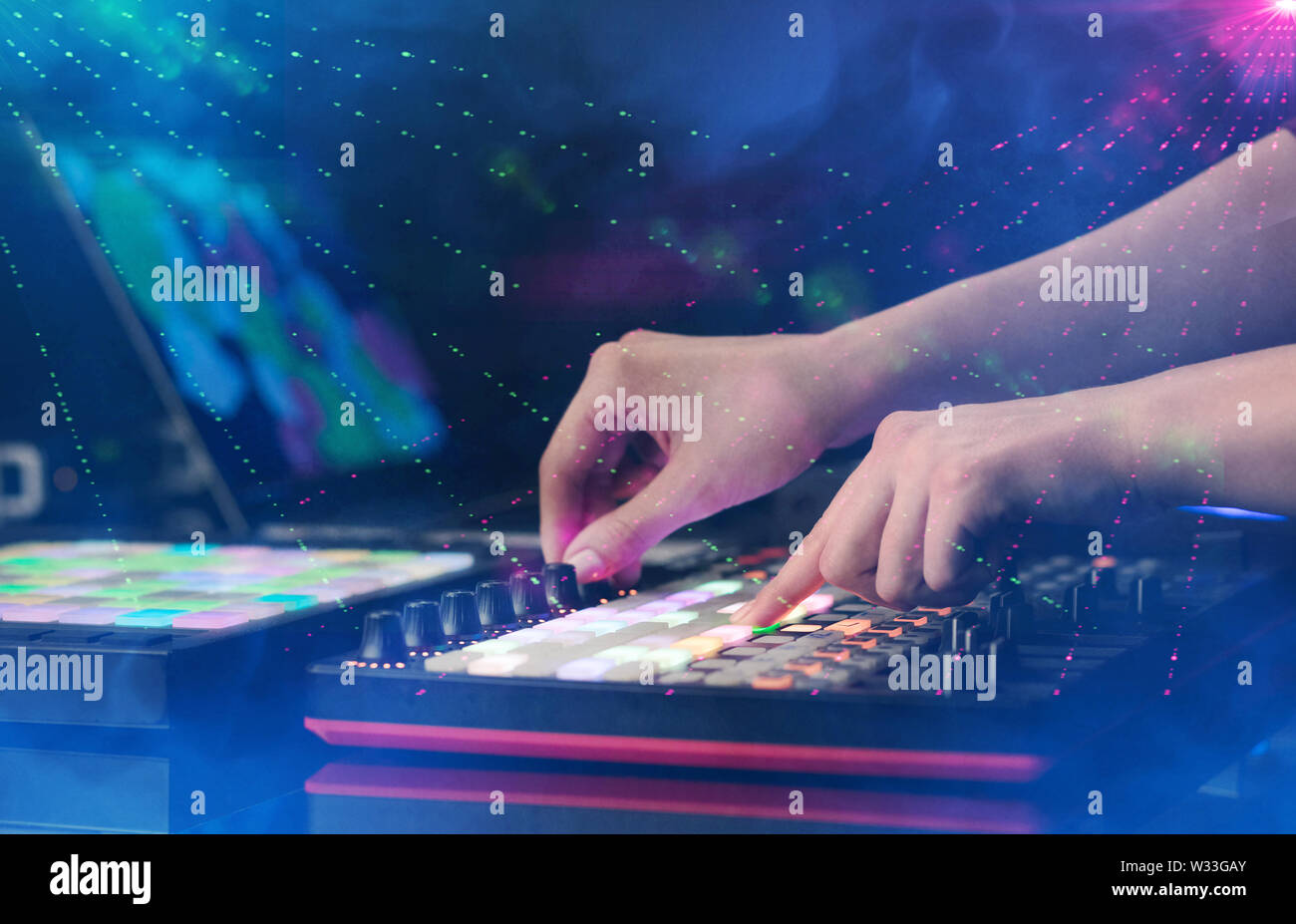 Hand mixing music on midi controller with party club colors around ...