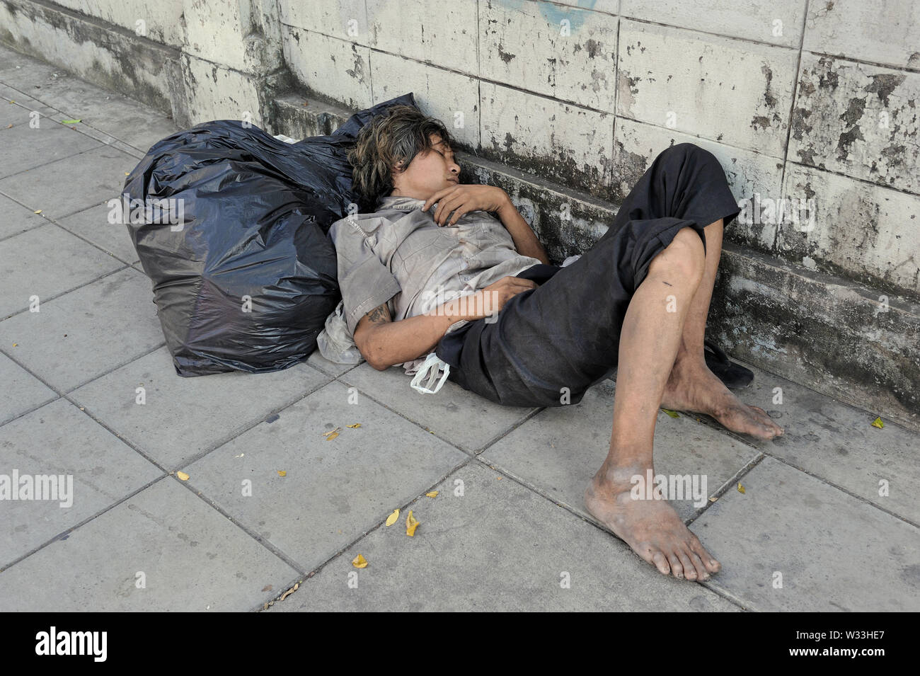 bangkok, thailand - december 23, 2010: a homeless young man sleeping on ...