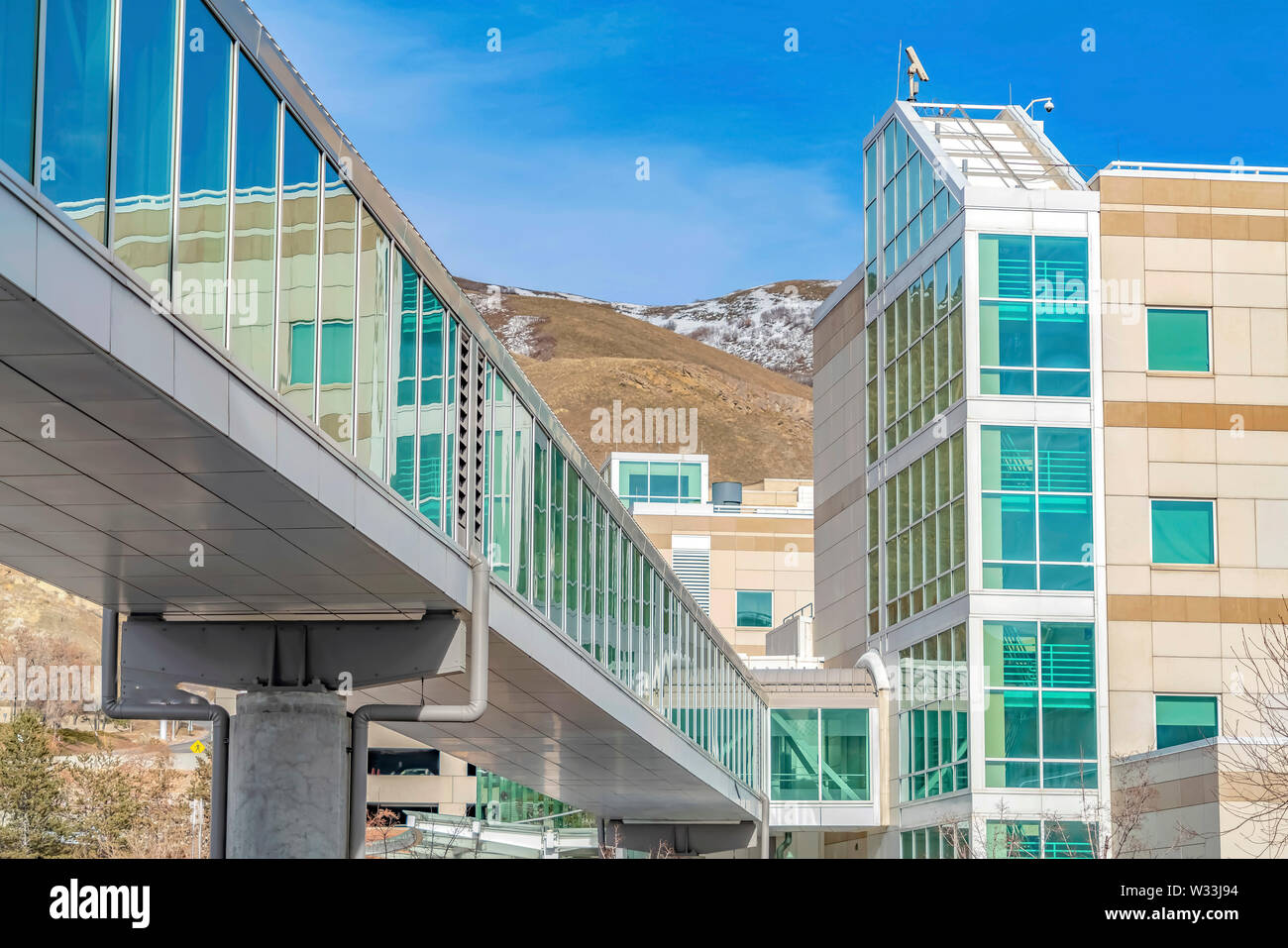 Skybridge connected to a modern building with mountain and blue sky ...