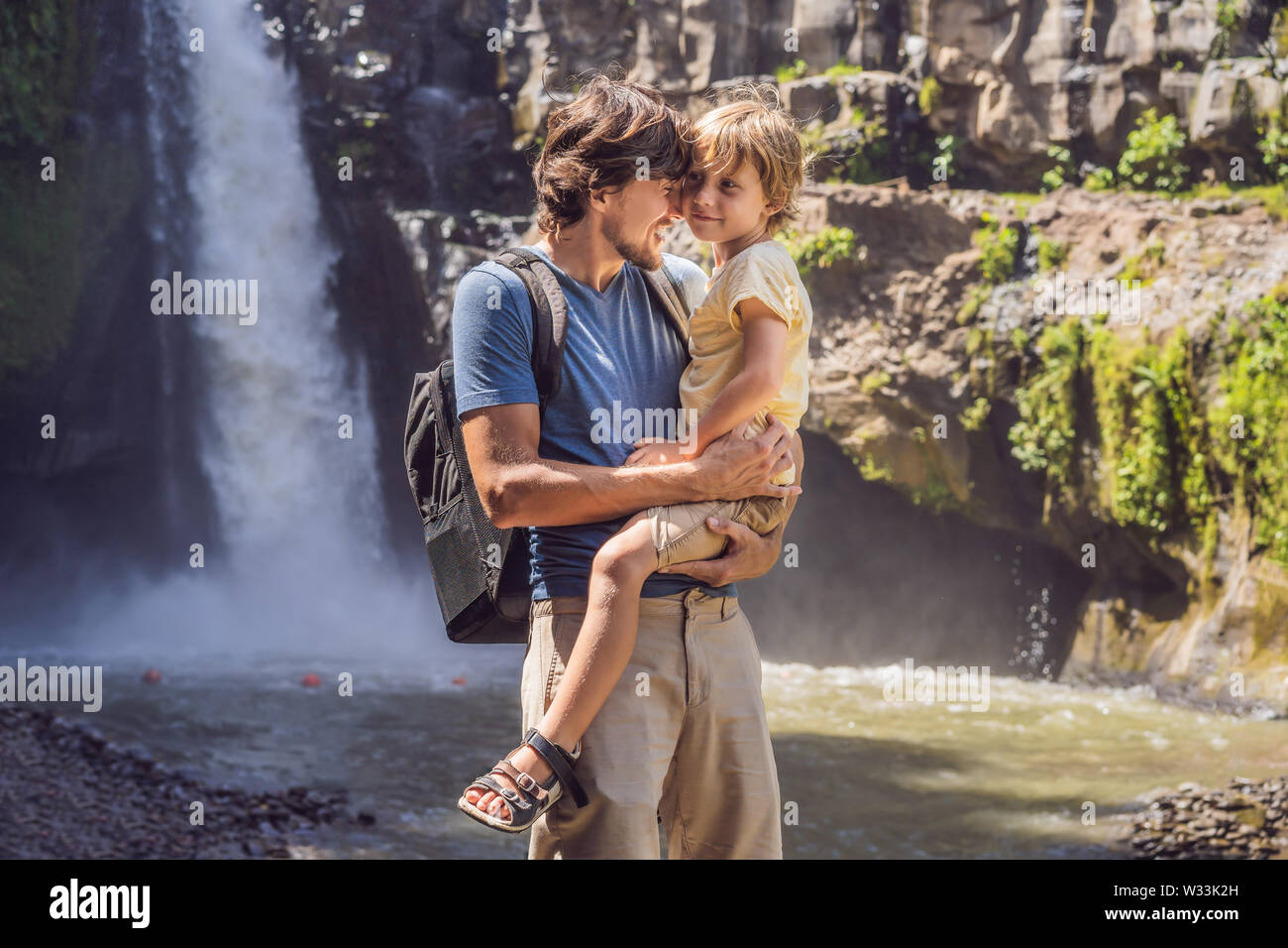 Dad and son tourists on the background of a waterfall. Traveling with ...
