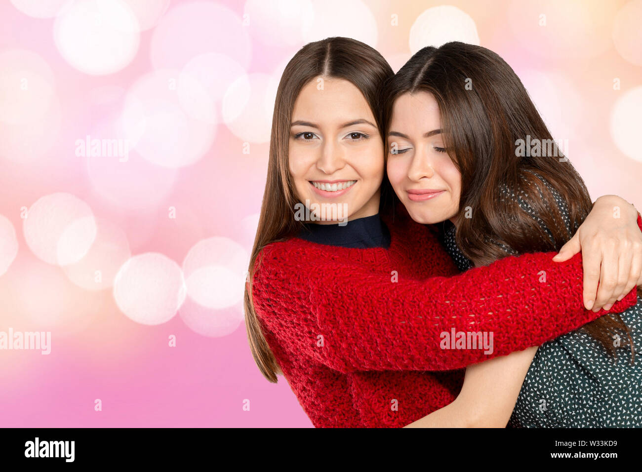 Two beautiful sisters hugging each other and smiling Stock Photo - Alamy