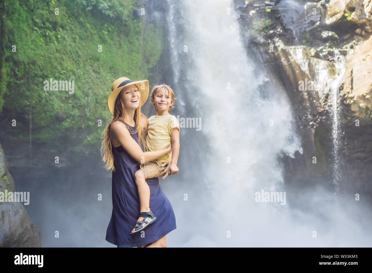 Mom and son tourists on the background of a waterfall. Traveling with ...