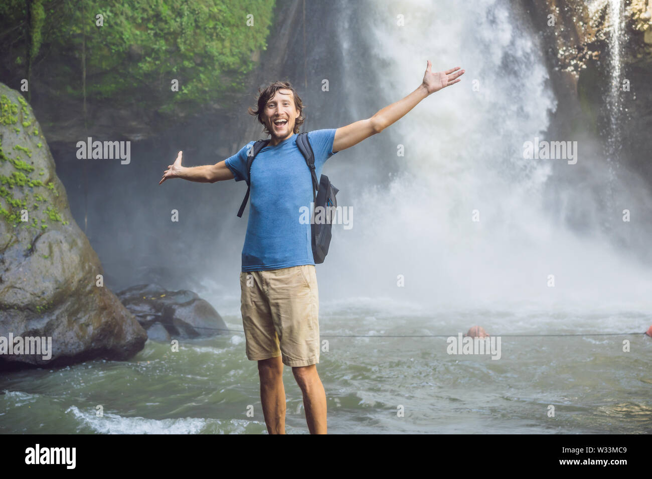 Man traveler on a waterfall background. Ecotourism concept Stock Photo ...