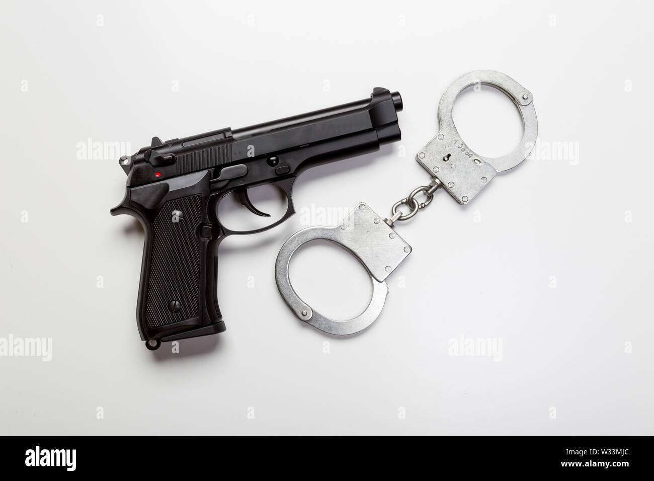 gun and handcuffs on white background Stock Photo - Alamy