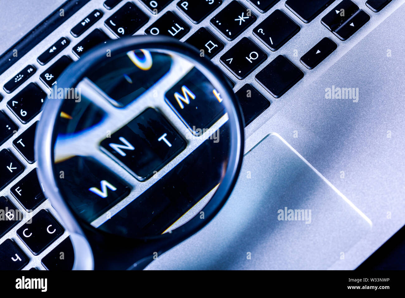 Closeup images of magnifying glass on laptop keyboard Stock Photo - Alamy