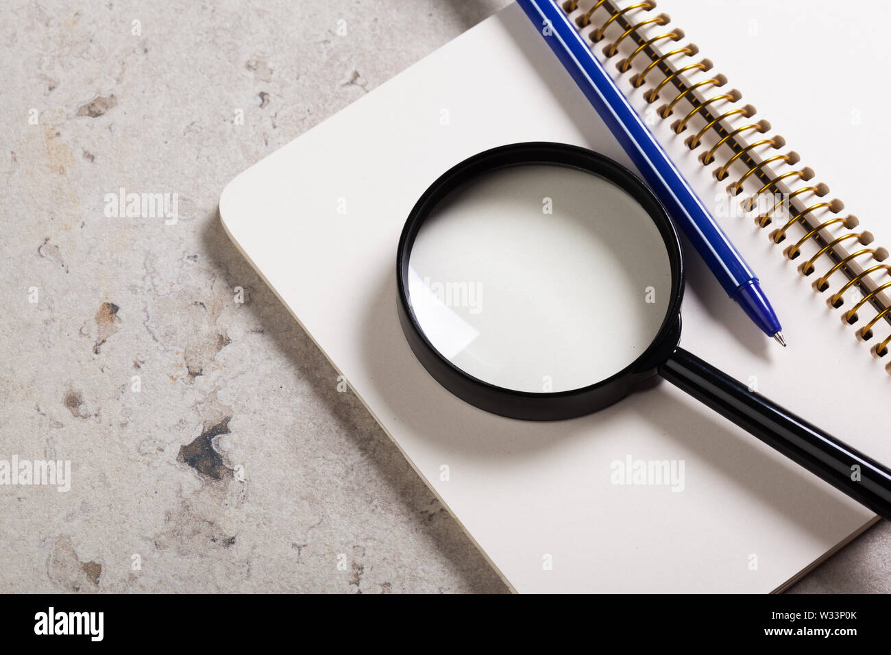 Notebook and magnifier Stock Photo - Alamy
