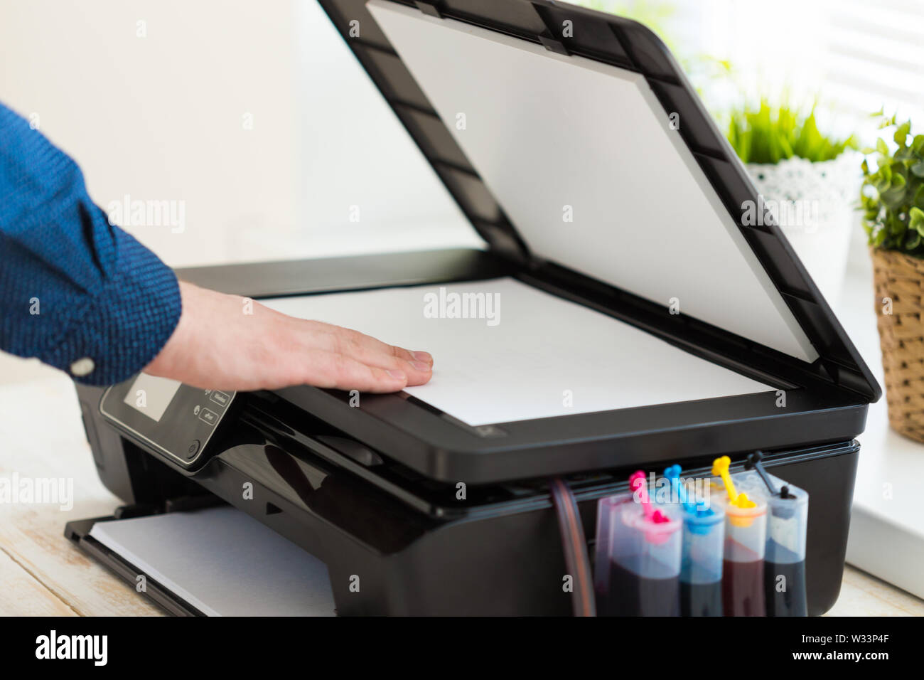 Man's hand making copies. Working with printer Stock Photo - Alamy