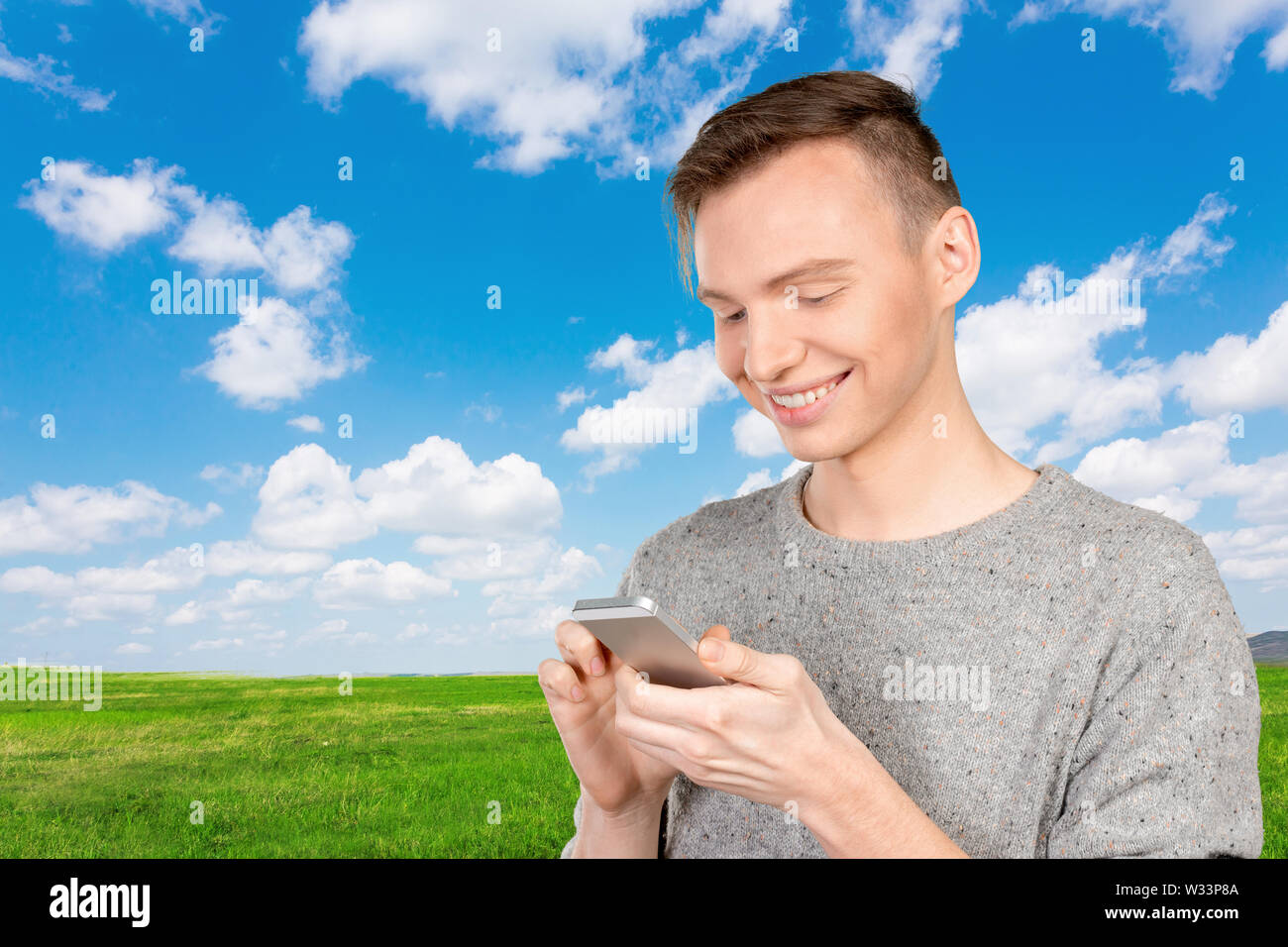 Young man typing text message on his cellphone Stock Photo - Alamy