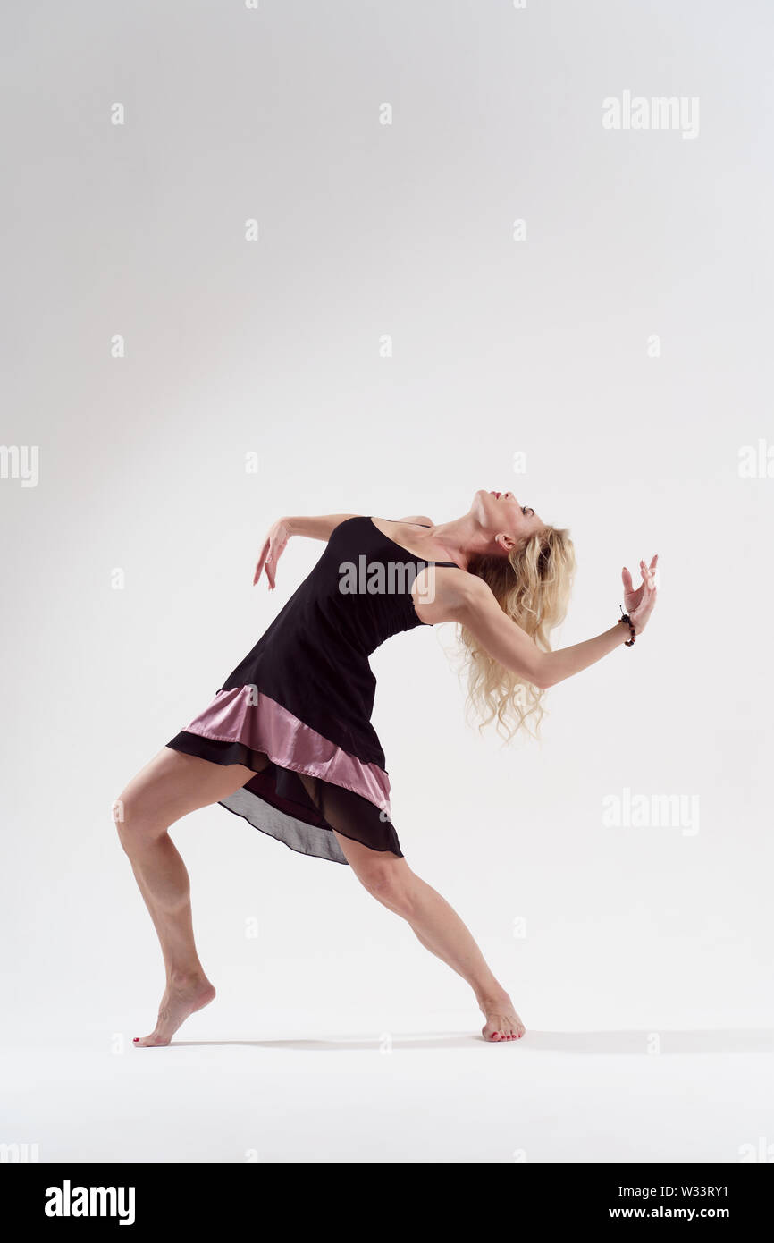 Photo of dancing girl leaning back with outstretched arm in short black ...