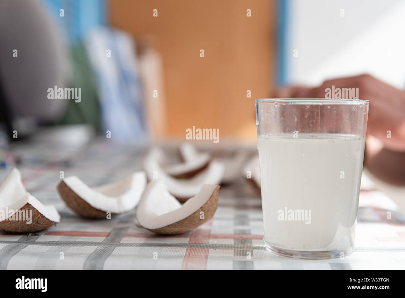 Coconut water and fresh pieces coconut on the table. Exotic food form ...