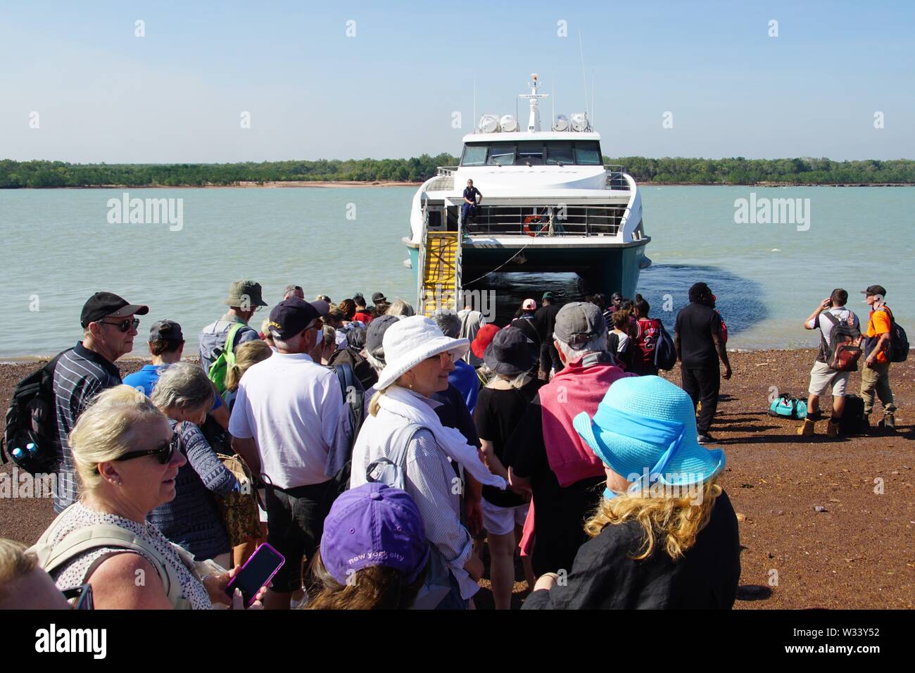 People queueing on the Beach to board a Ferry Stock Photo - Alamy