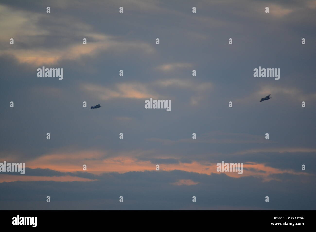 evening sunset, clouds with C130 hercules transport aircraft flying in ...
