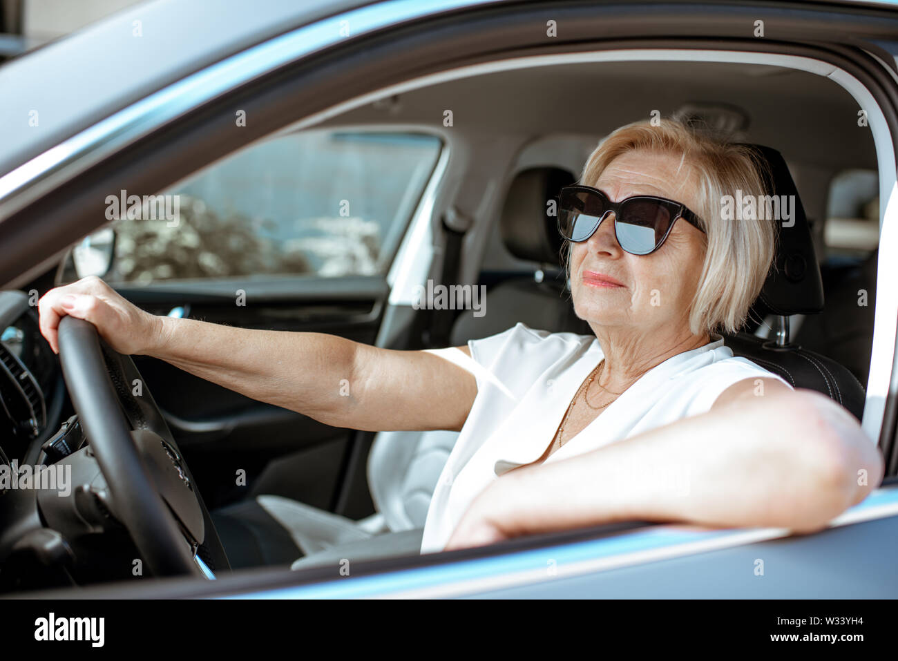 Portrait of a senior woman driver sitting in the modern car Stock Photo ...