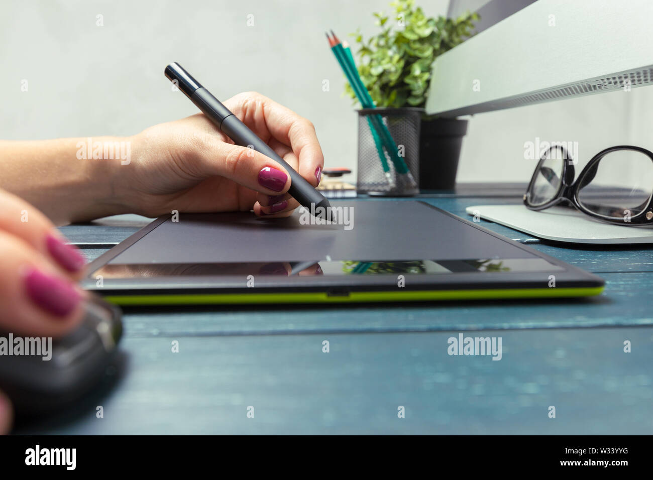 Hand of graphic designer working with stilus and tablet Stock Photo - Alamy