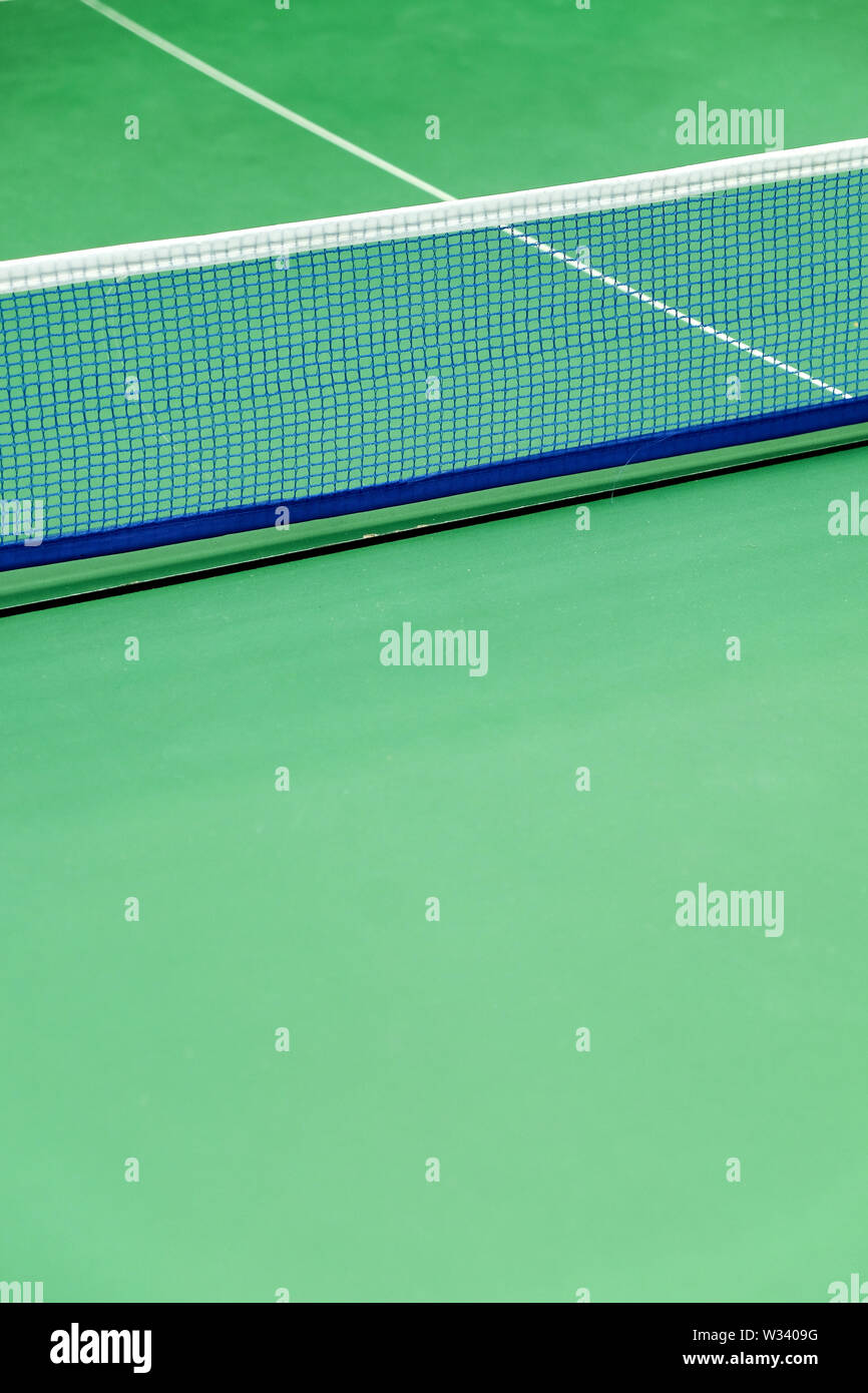 Net of tennis court on green wall background Stock Photo - Alamy