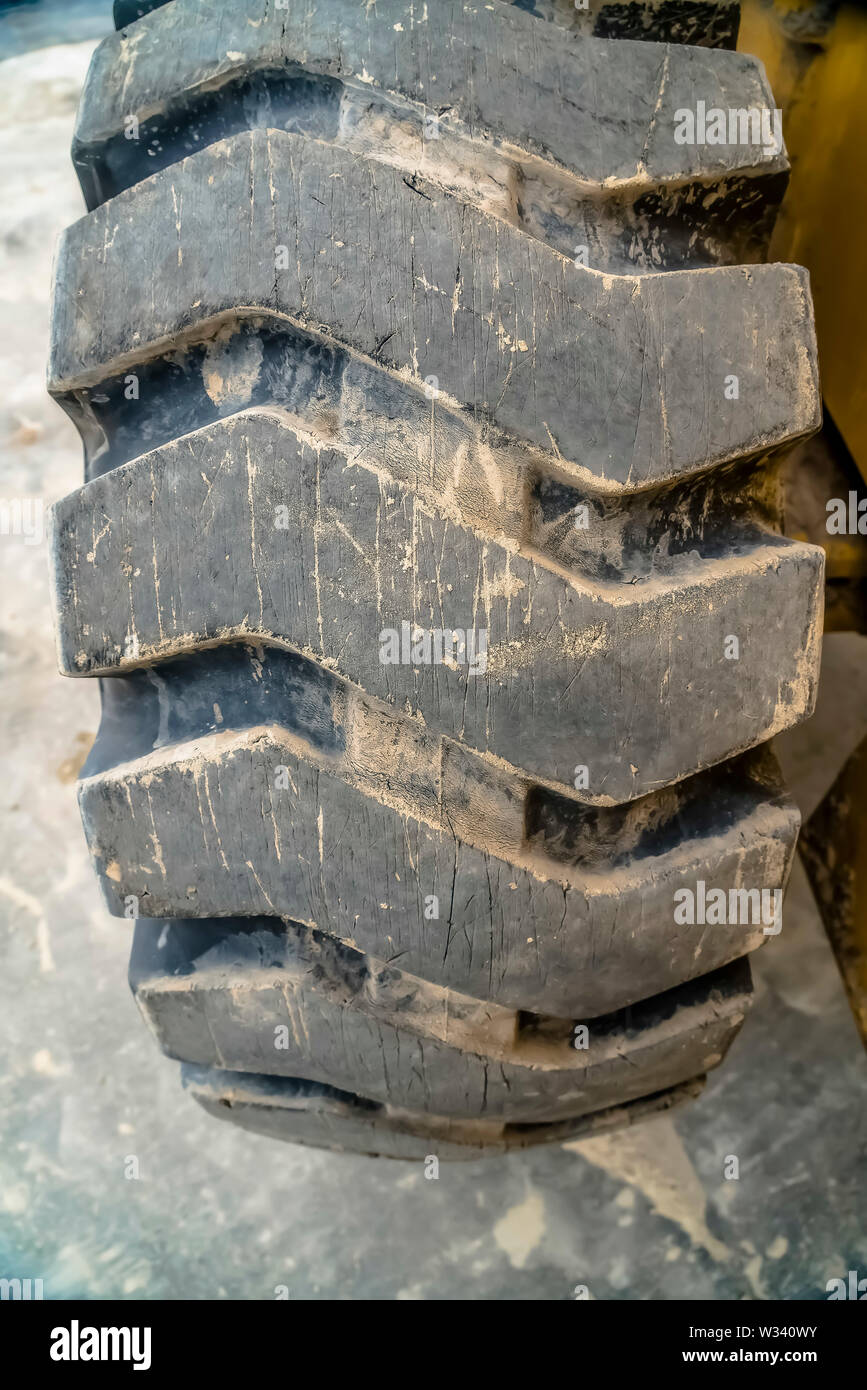 Details of the thick and heavy duty wheel of a yellow construction ...