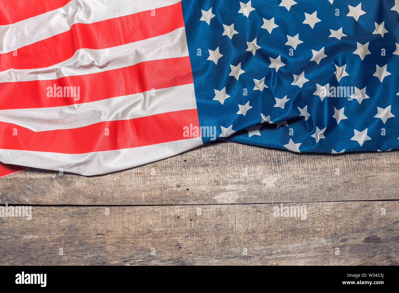 An American Flag Lying on an aged, weathered rustic wooden background ...