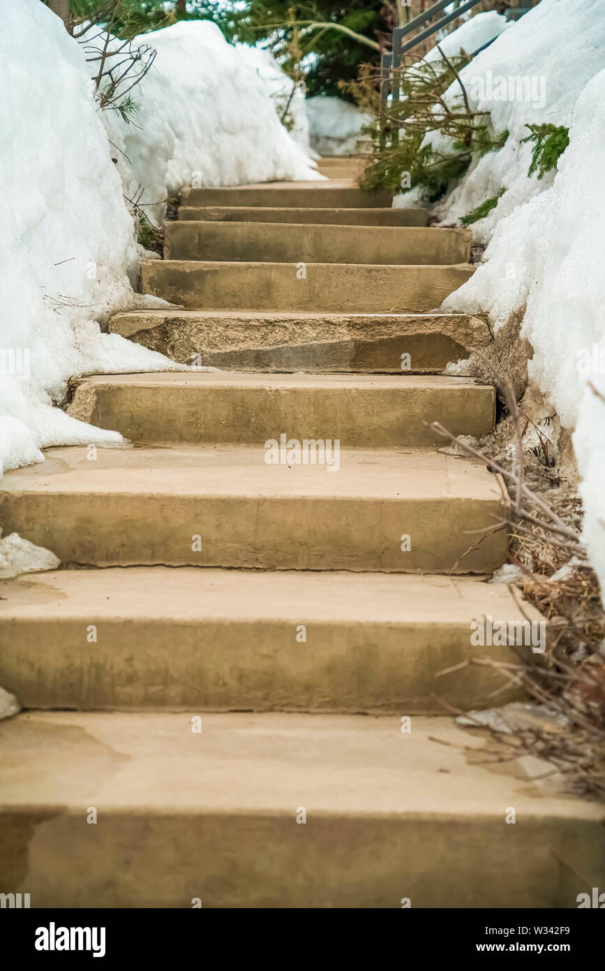 Close up of concrete outdoor steps on a slope covered with fresh snow ...