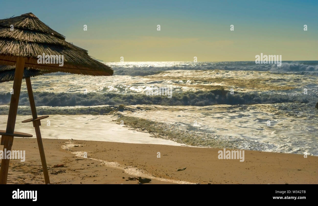 Straw parasols at Atlantic ocean beach, Portugal Stock Photo - Alamy
